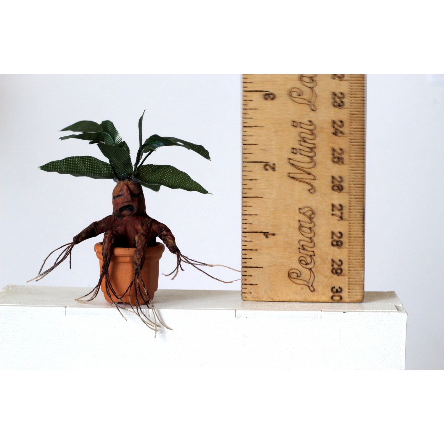 Miniature mandragora root plant in the pot, dollhouse figurine scream
